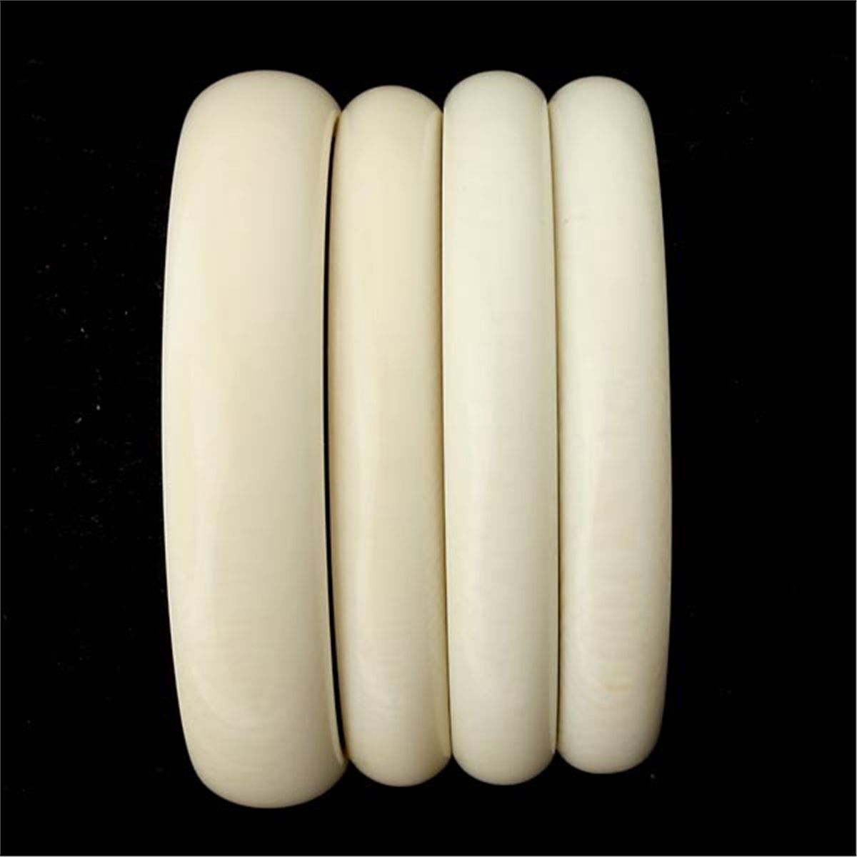 COLLECTION OF FOUR CARVED IVORY BANGLES.