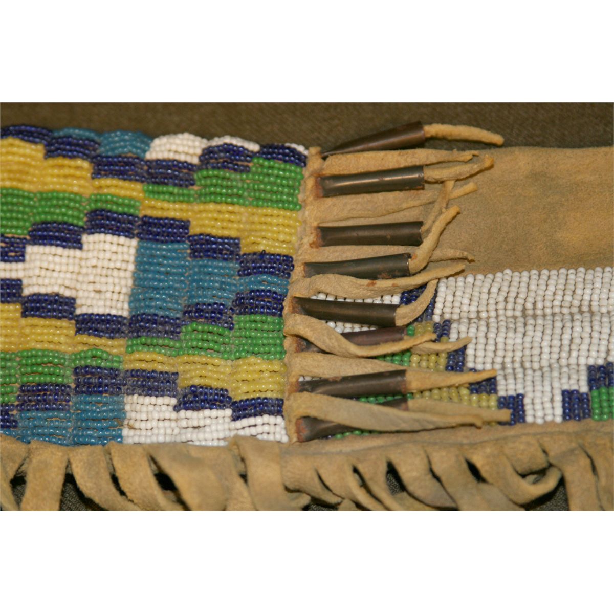 Beaded knife case with tin cone tassels.