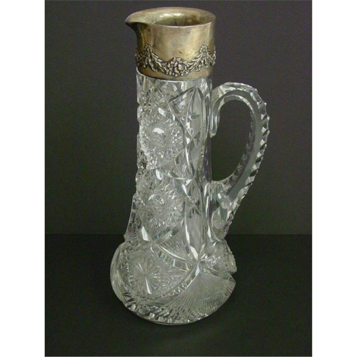Cut glass pitcher with silver rim