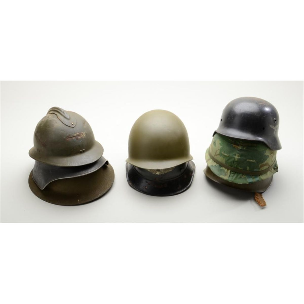 Lot of eight military metal helmets including a US helmet and liner ...