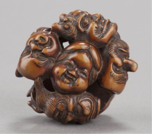 A wood ryusa netsuke of group of nine Noh masks.
