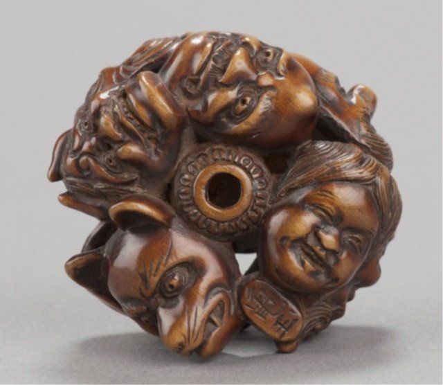 A wood ryusa netsuke of group of nine Noh masks.