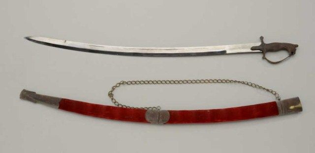 Curved blade sword and red material covered metal scabbard with hanging ...