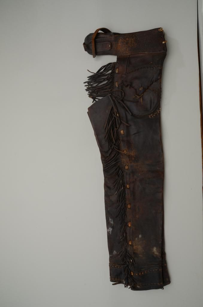 A pair of cowboy chaps and a pair of leather pants from an old estate ...