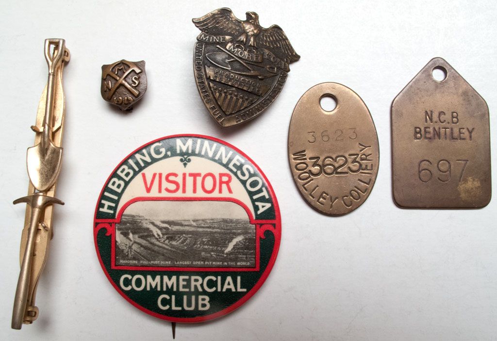 Assorted mining badges, pins, and tags