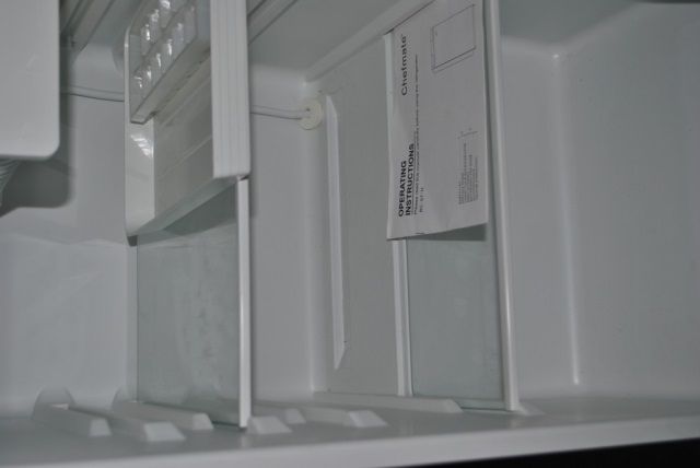 A small black and silver mini fridge by Chefmate