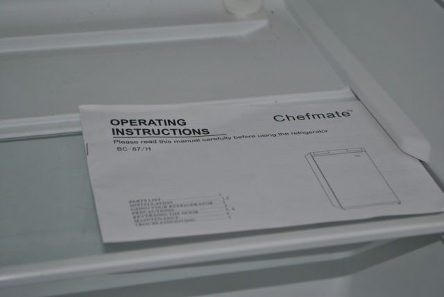 A small black and silver mini fridge by Chefmate