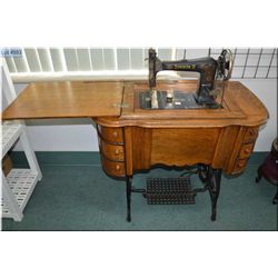 Dominion sewing machine in quarter cut oak cabinet
