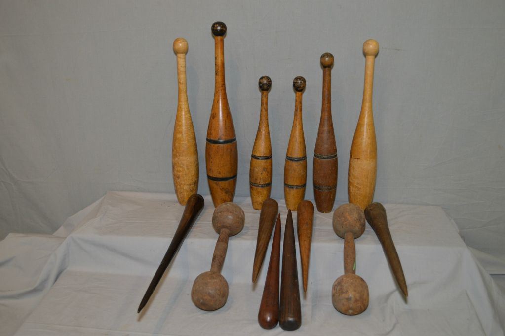 Selection of antique juggling batons, cast iron free weights