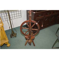 An antique upright wooden spinning wheel with accessories