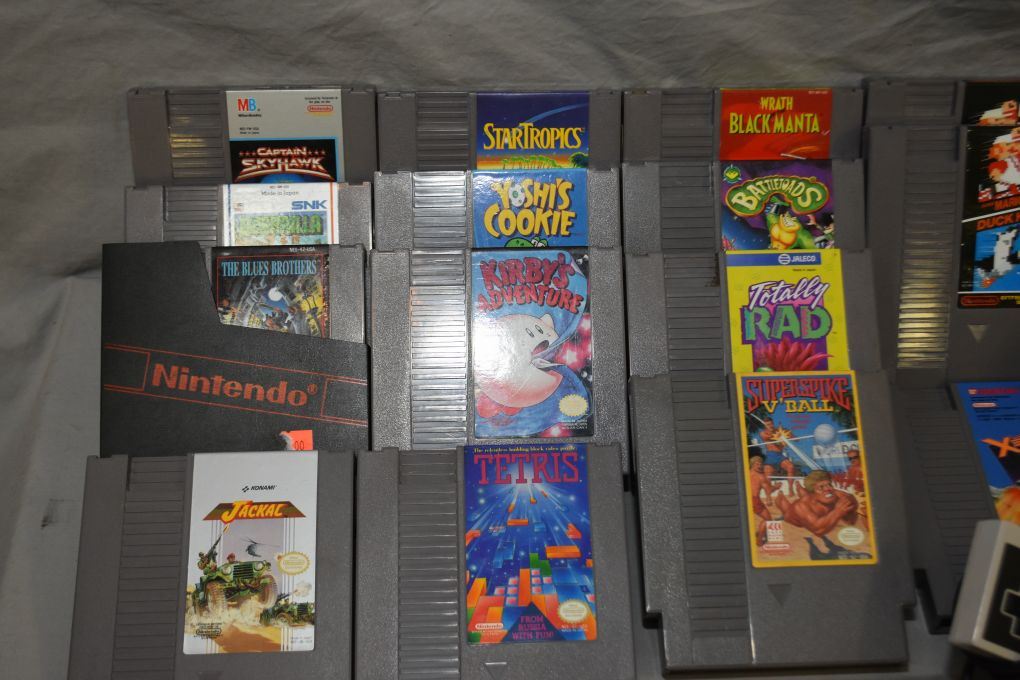 Two vintage Nintendo game consoles with power cords, four controllers ...