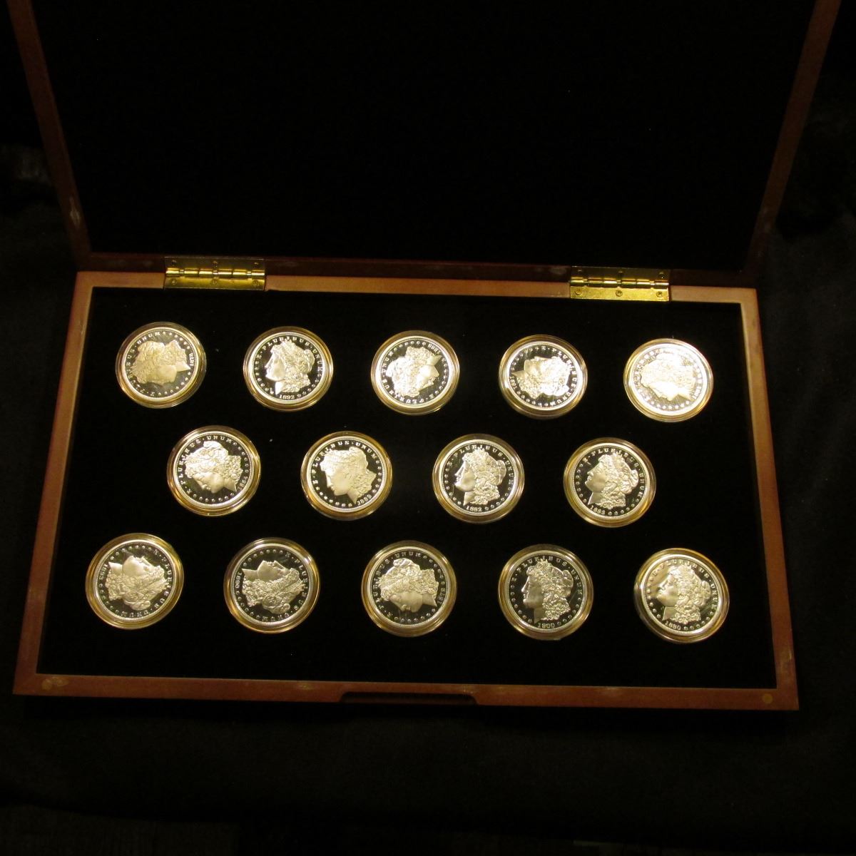 REPLICA MORGAN DOLLAR SET IN A HARDWOOD DISPLAY CASE. THERE ARE 14 ...