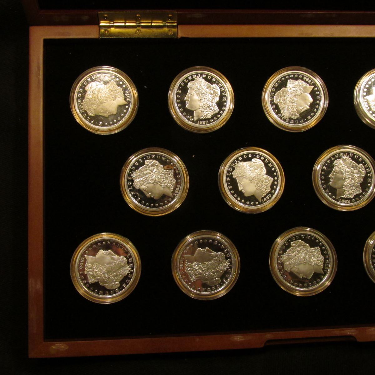 REPLICA MORGAN DOLLAR SET IN A HARDWOOD DISPLAY CASE. THERE ARE 14 ...