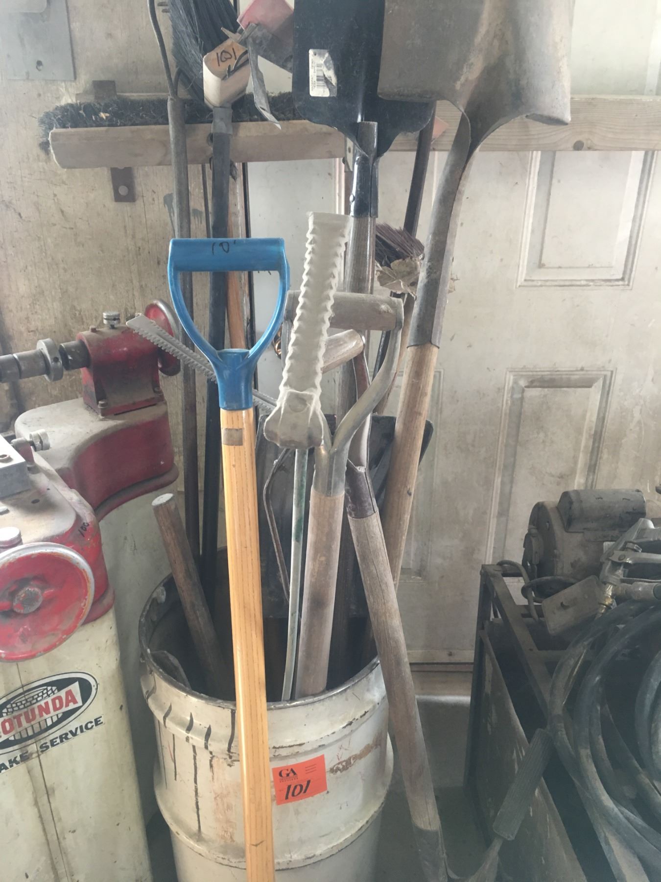 Barrel w/brooms, axe, crowbar, sledge hammers, rakes, squeegee, shovels ...