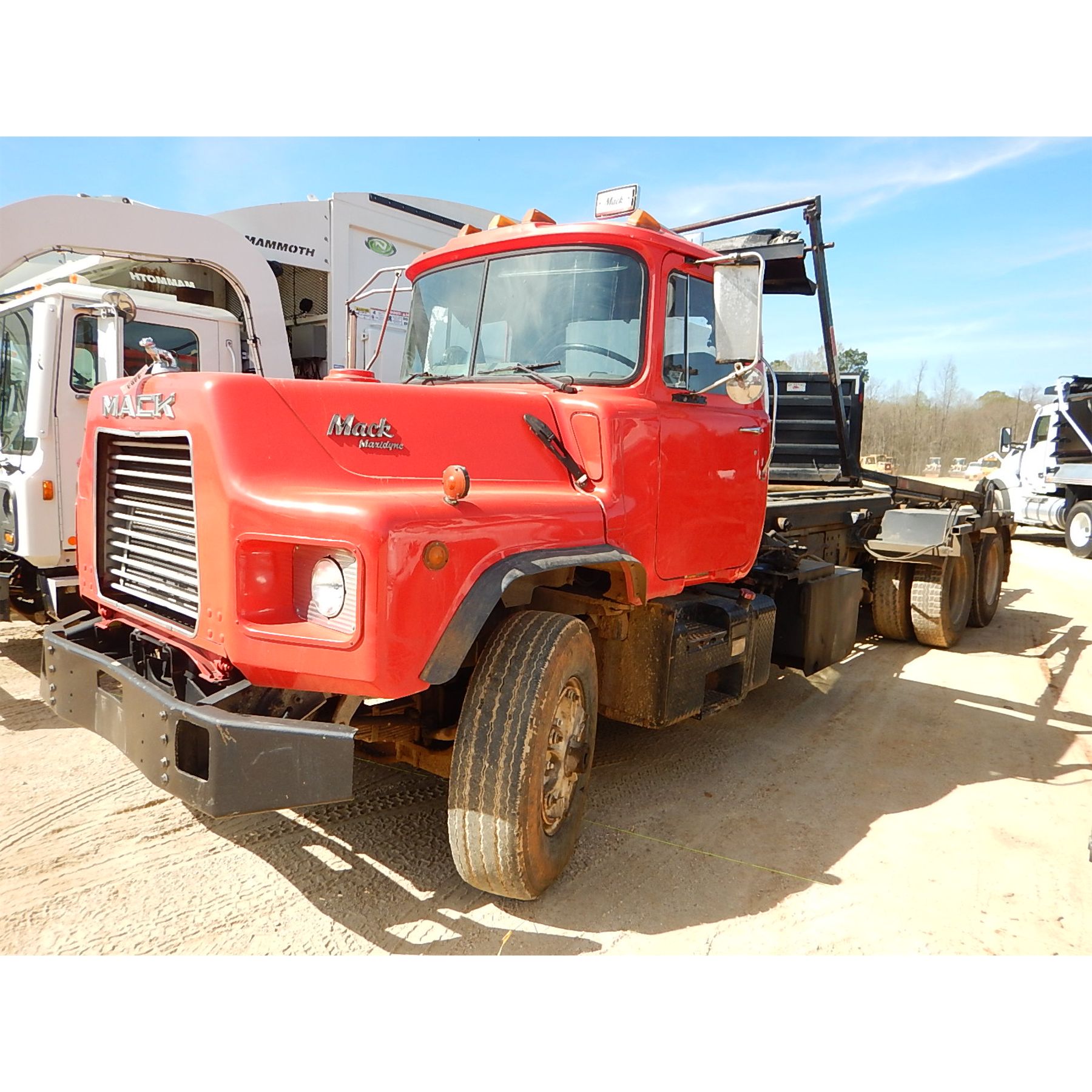 1991 MACK DM690S Roll Off Truck - J.M. Wood Auction Company, Inc.