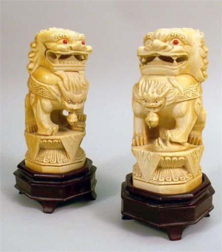 A PAIR OF CARVED IVORY FOO DOGS