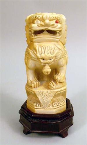 A PAIR OF CARVED IVORY FOO DOGS