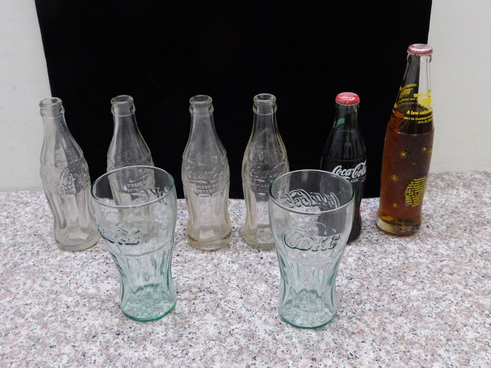 Lot of 8 Vintage Coca Cola Empty Bottles From 1938 - 1957 2 FULL Bottles Tab and Coke 2 Mugs
