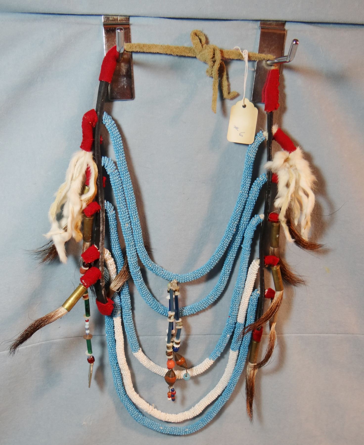 Blue beaded neck piece, ermine tails, trade cloth, deer hair and bullet ...