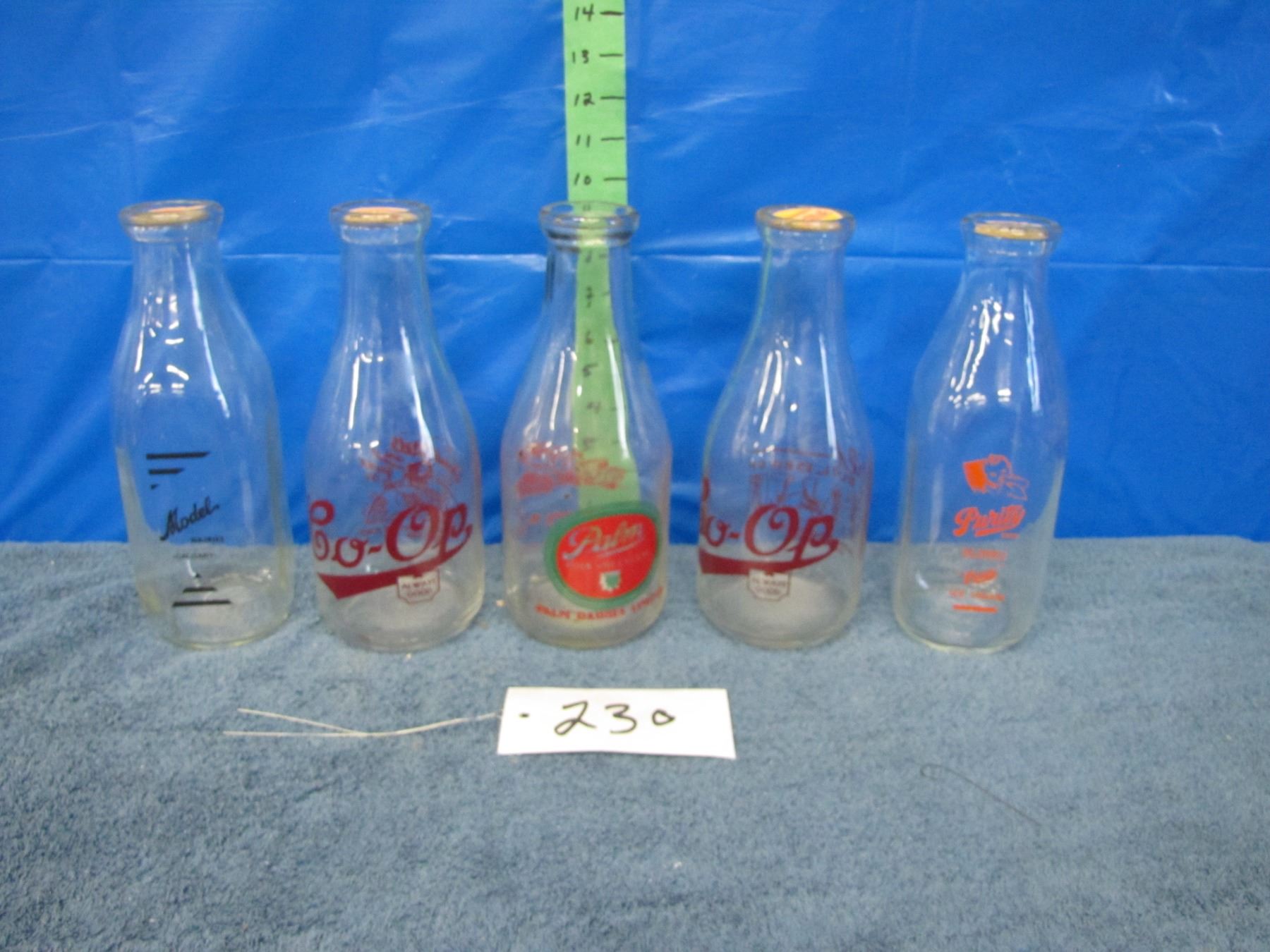 Collection of glass milk jugs labeled
