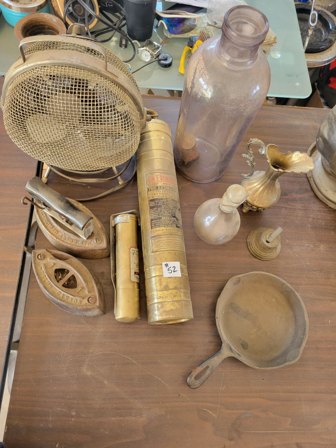 2 sad irons, fans, fire ext., purple vase, small bell, frying pan.