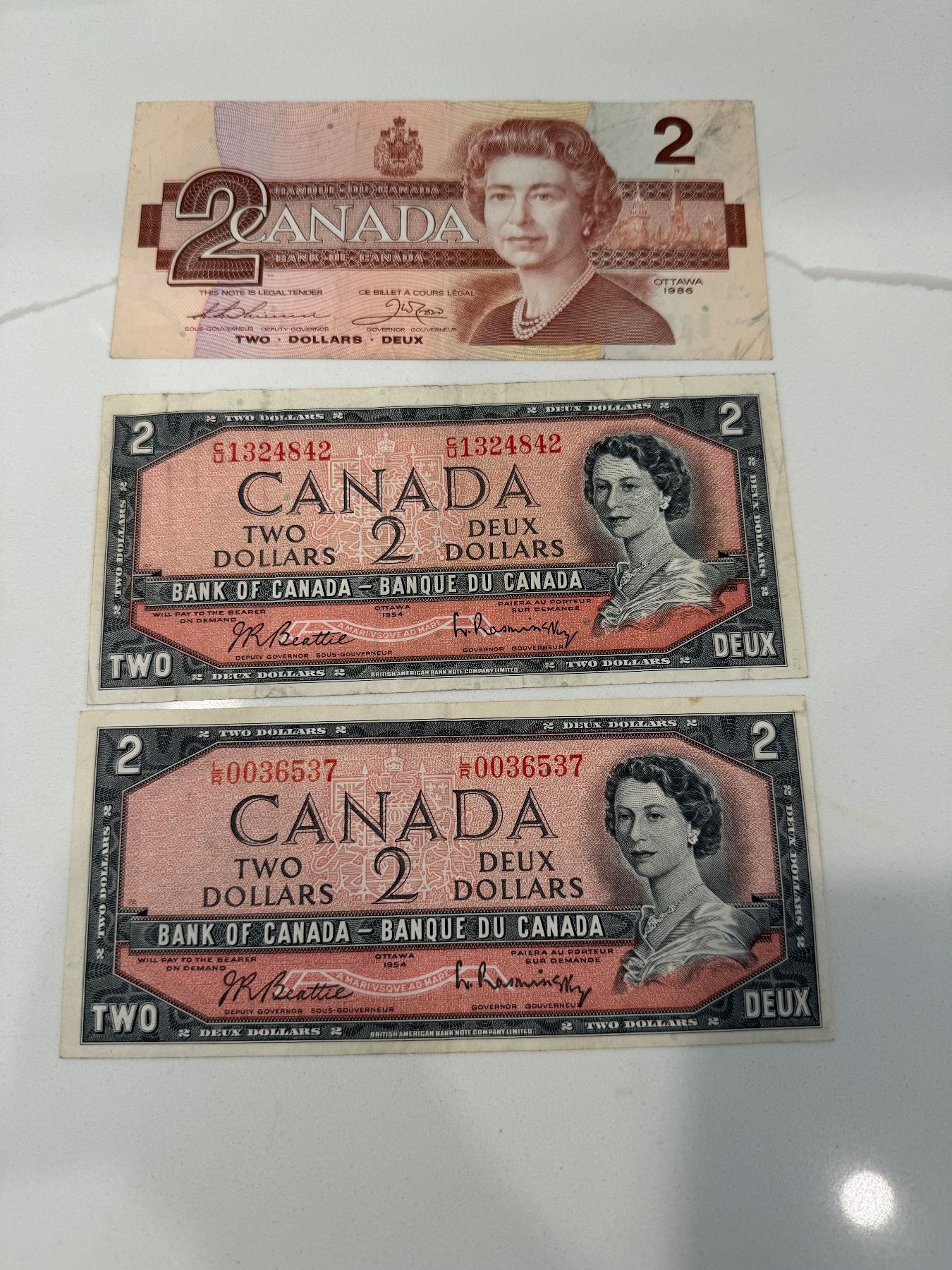 Two 1954 Canada two dollar bills and one 1986 Canada two dollar bill