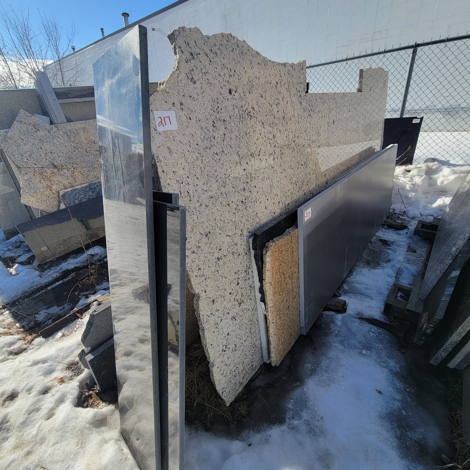 Qty of large partial slabs of various granite & quartz c/w metal A-frame