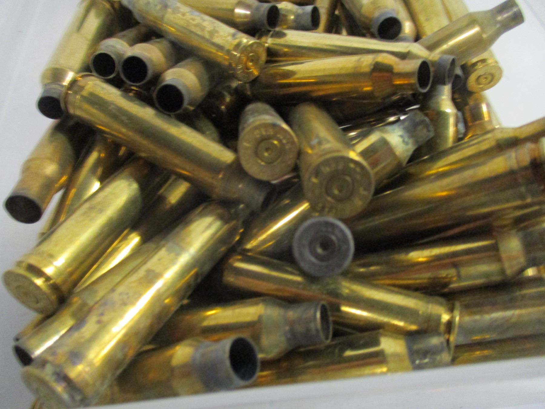 PLASTIC CONTAINER C/W BRASS SHELLS