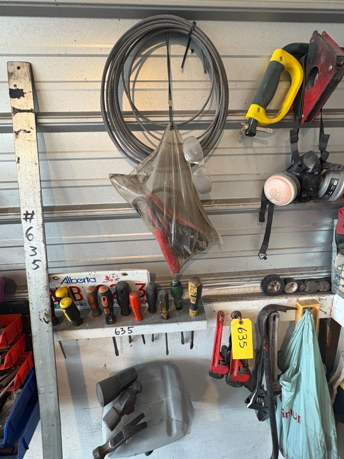 Contents on wall- screwdrivers, pipe wrenches, hammers, magnet, cable ...