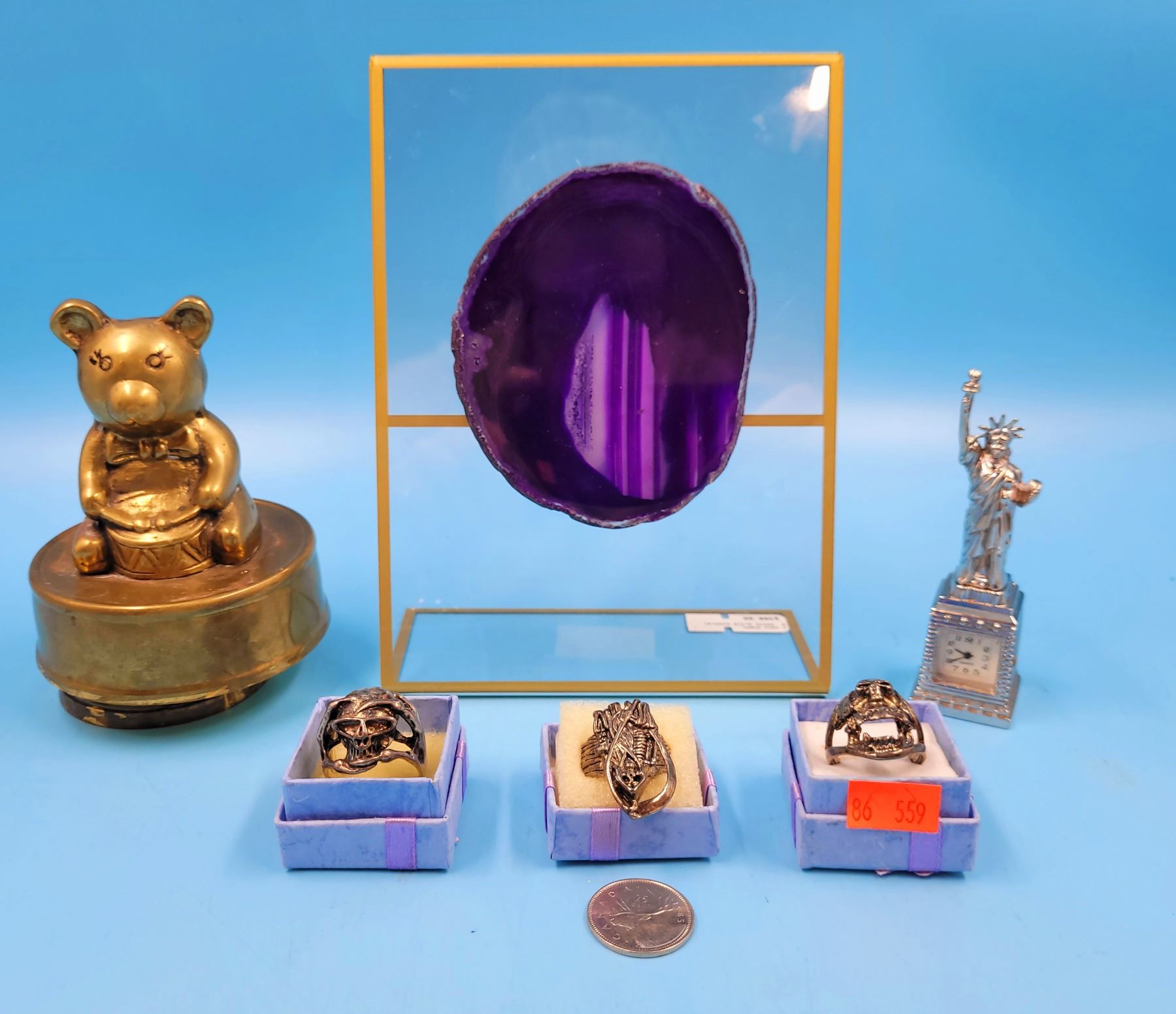 Miscellaneous Lot w/ Biker Rings, Brass Bear Music Box, Argate Slab, & More