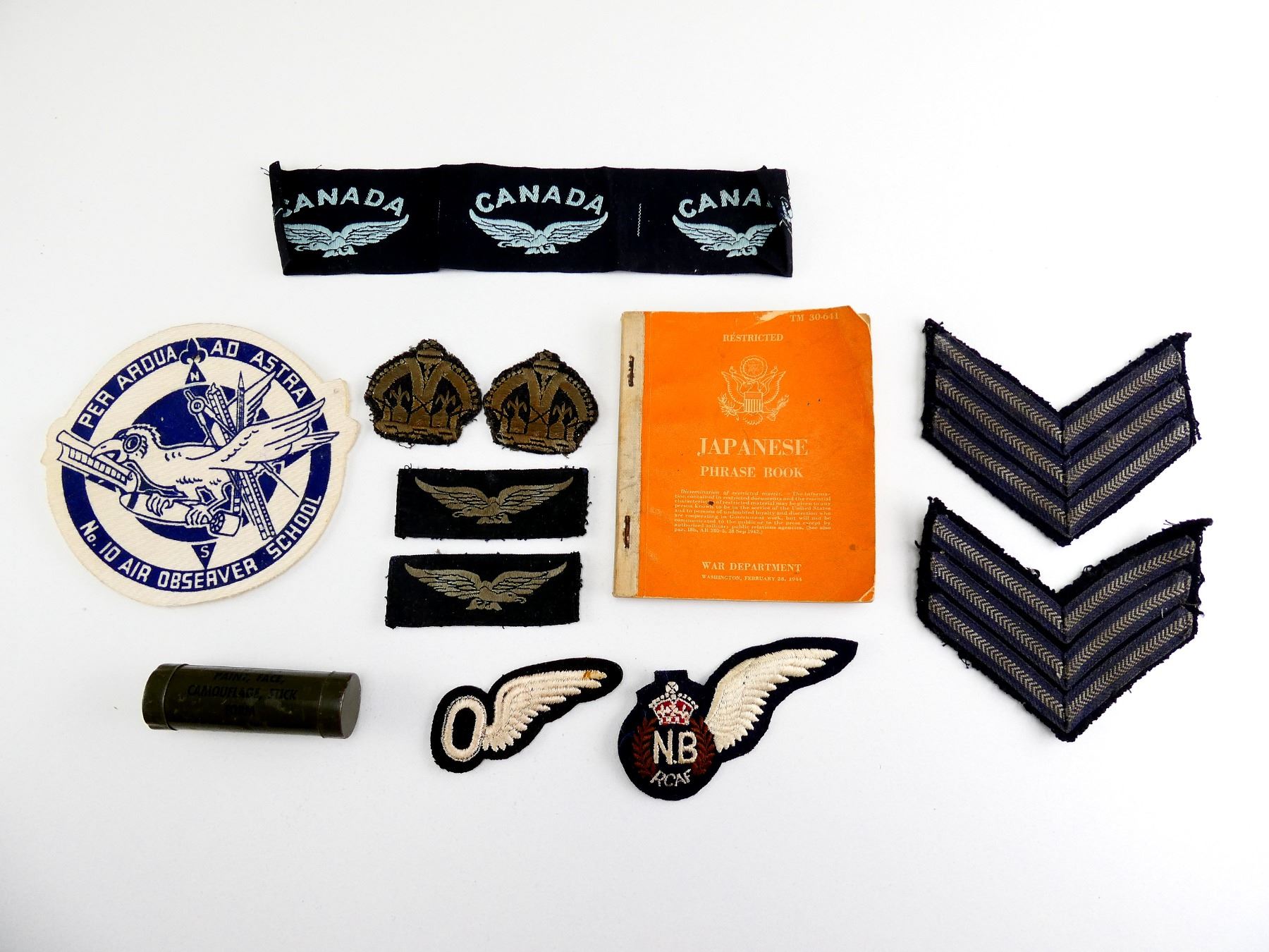 ASSORTED WWII MILITARY BADGES, BOOKLET, ETC. LOT