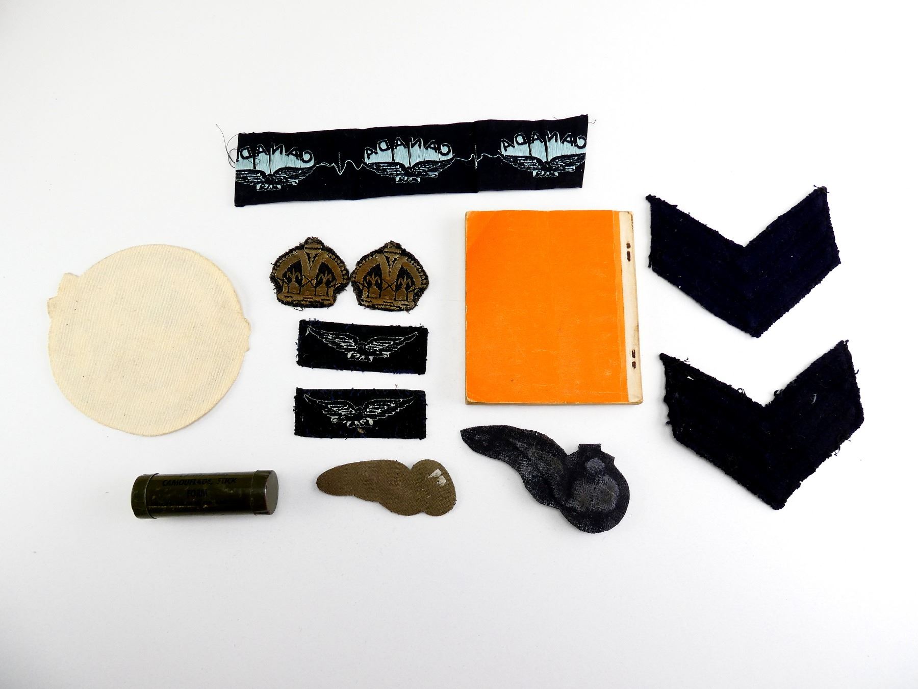 ASSORTED WWII MILITARY BADGES, BOOKLET, ETC. LOT