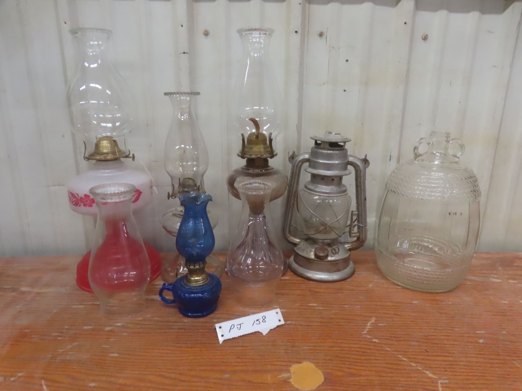 Four Oil Lamps, Lantern, Extra Chimneys, and Glass Jug