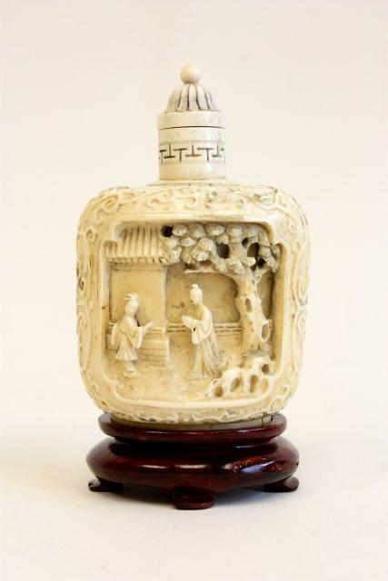 Carved ivory snuff bottle on wood stand